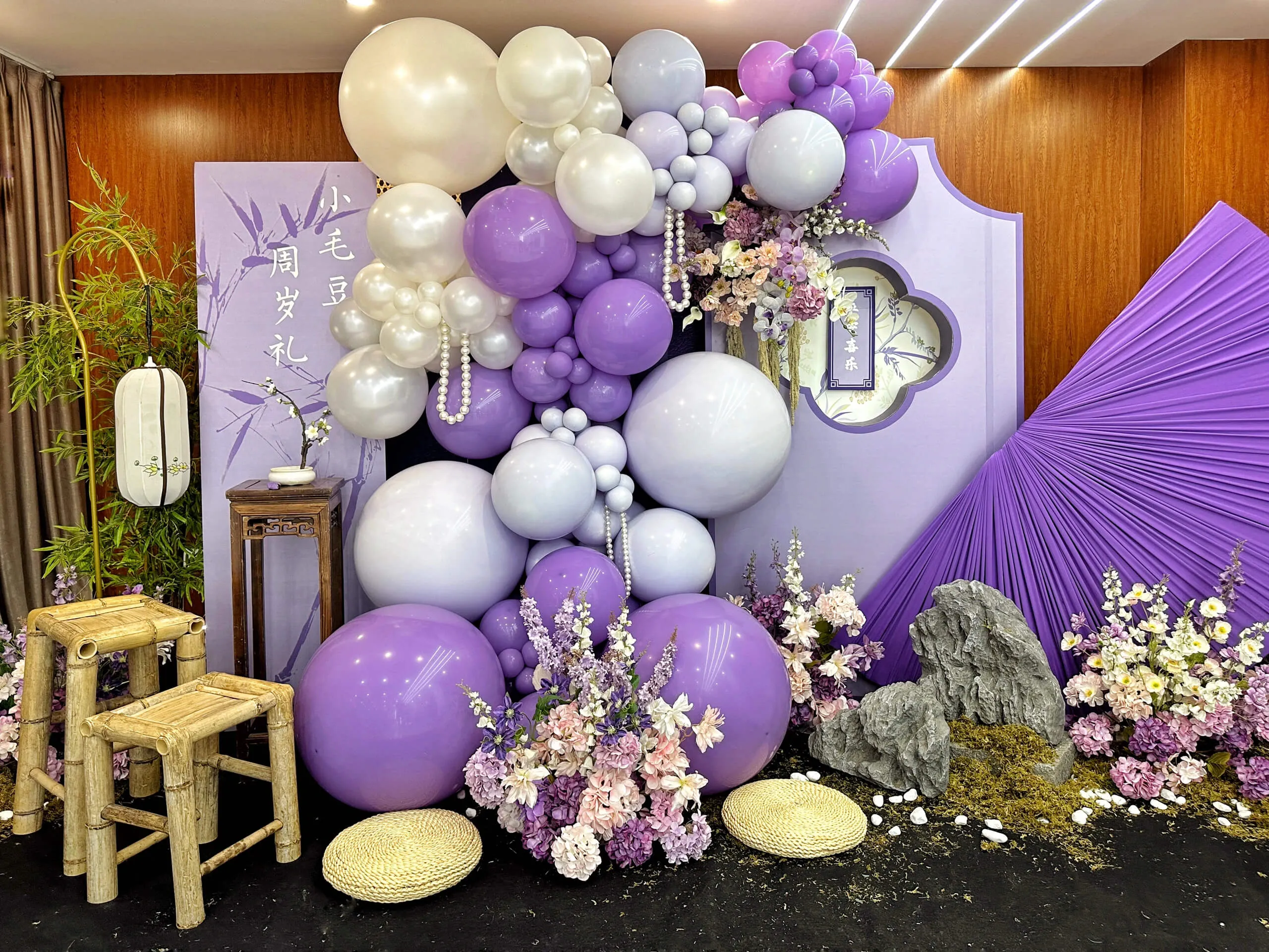Combination of purple color balloon decoration and floral arrangement ...